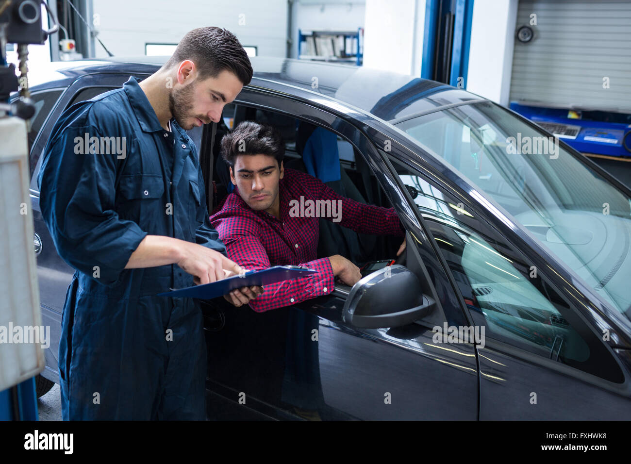 Mechanic showing the quotation to a customer Stock Photo - Alamy