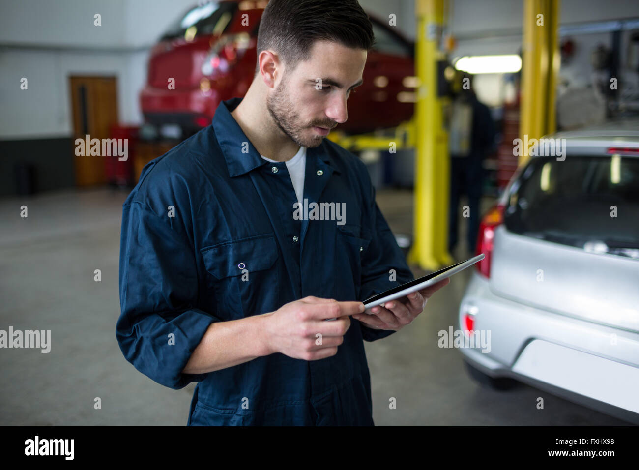Mechanic using digital tablet Stock Photo - Alamy