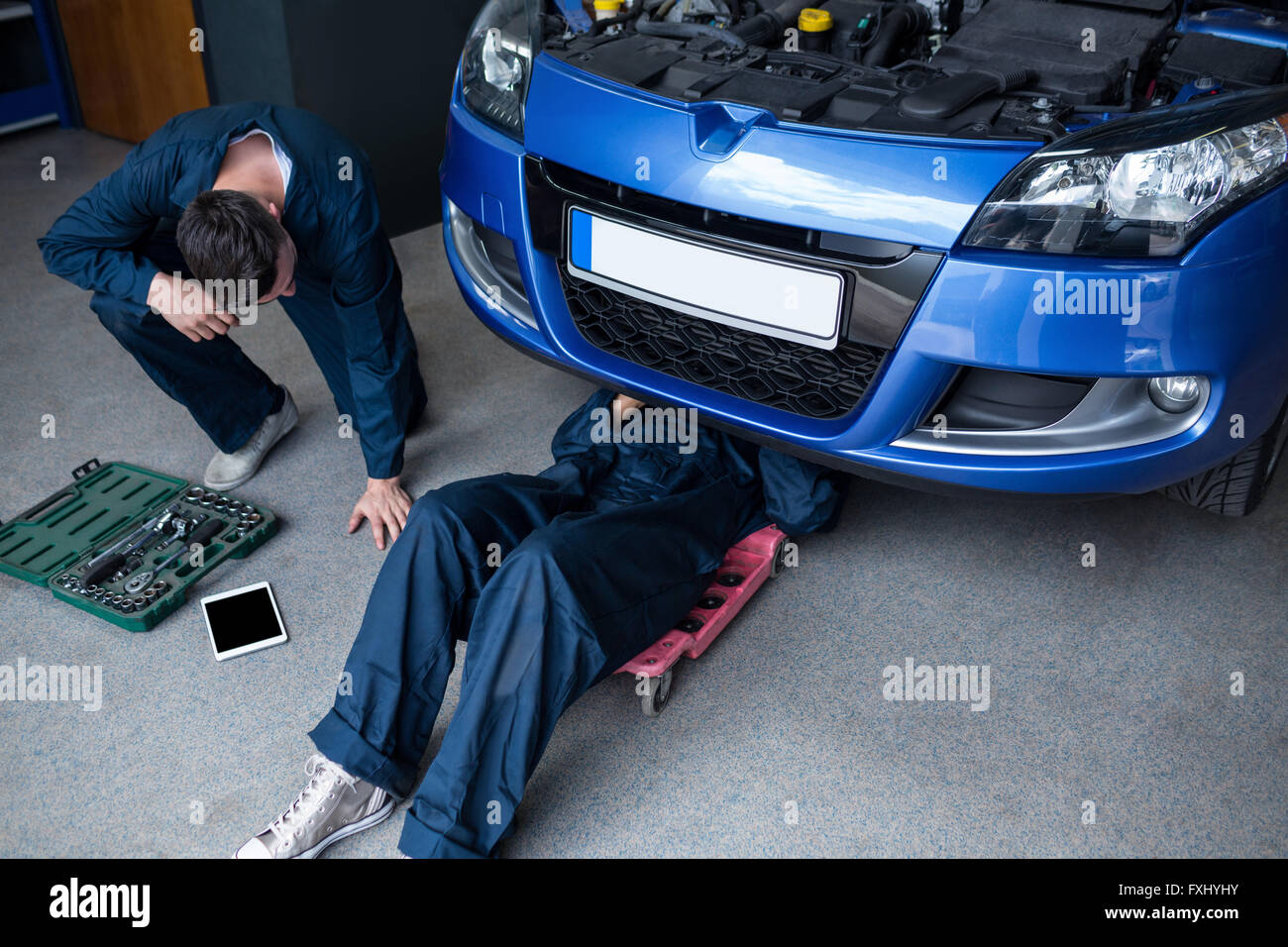 Mechanics repairing a car Stock Photo - Alamy