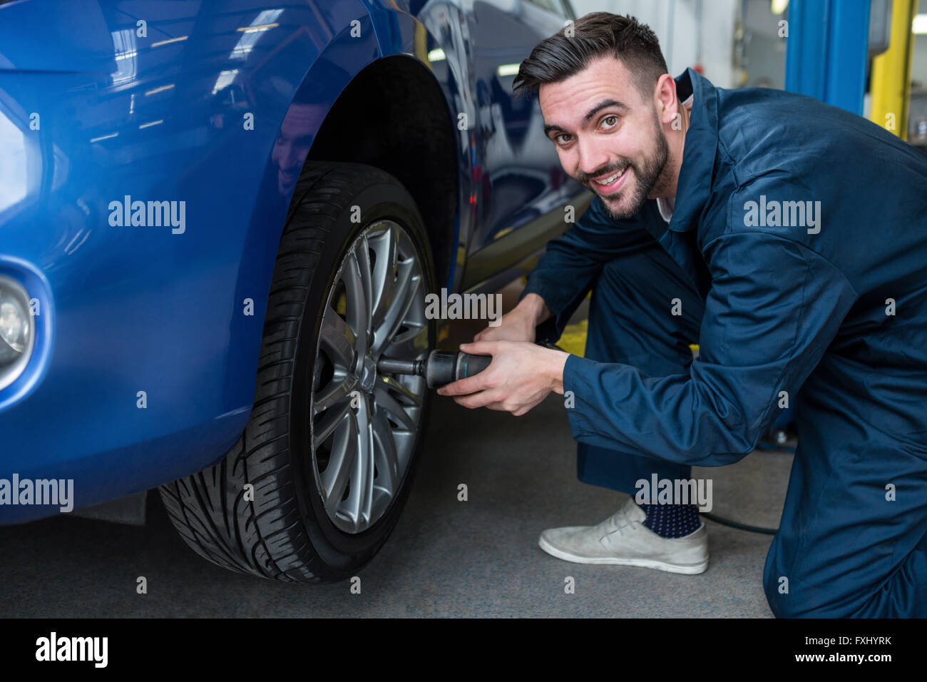 Mechanic fixing a car wheel Stock Photo - Alamy