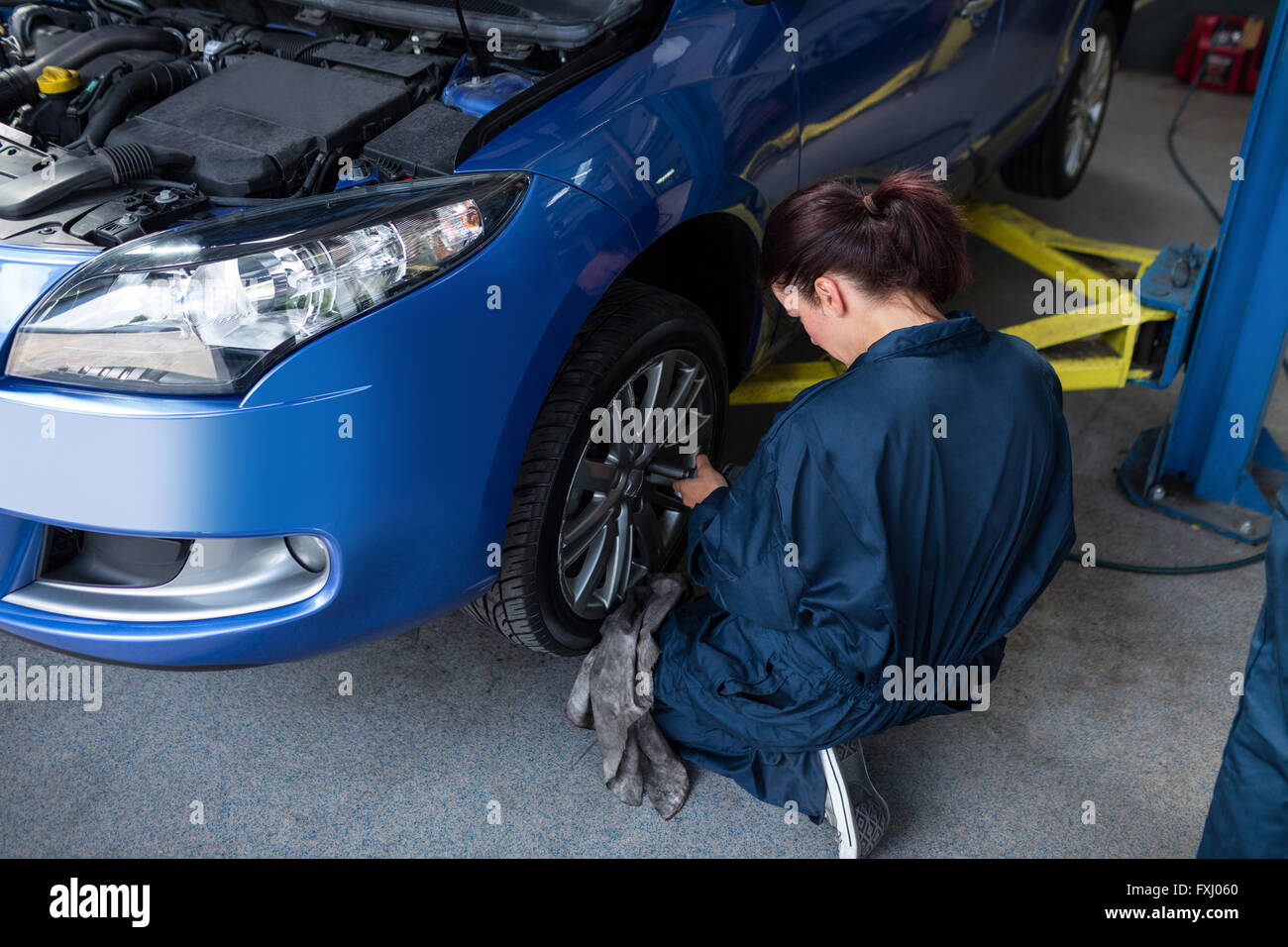Female mechanic fixing a car wheel Stock Photo - Alamy