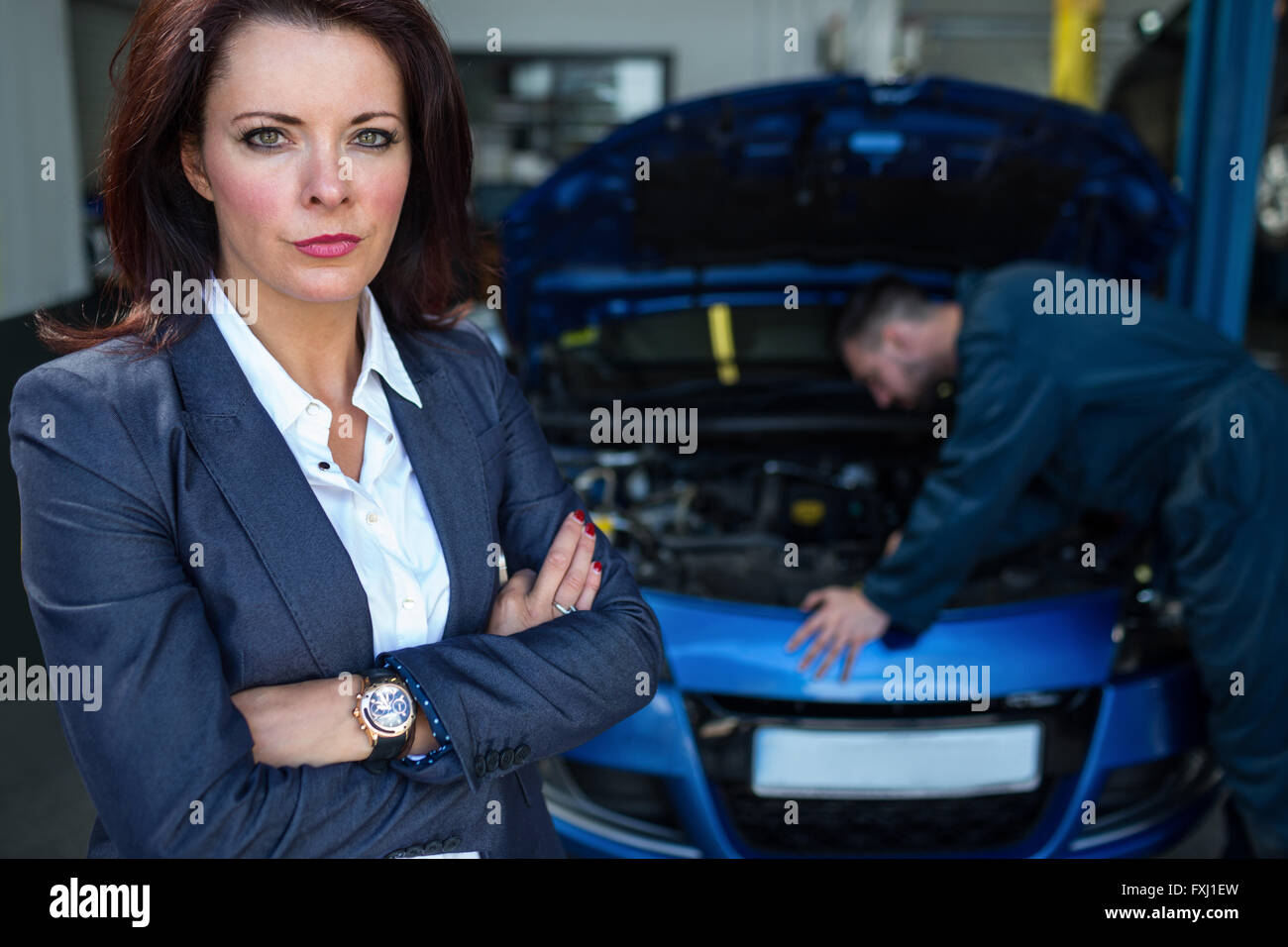 Customer looking at camera while mechanic examining car Stock Photo - Alamy