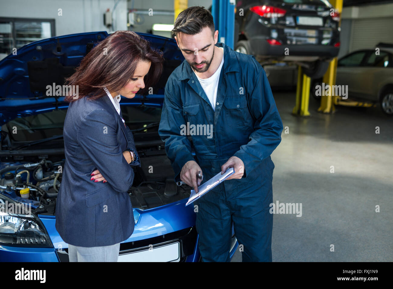 Mechanic showing the quotation to a customer Stock Photo - Alamy