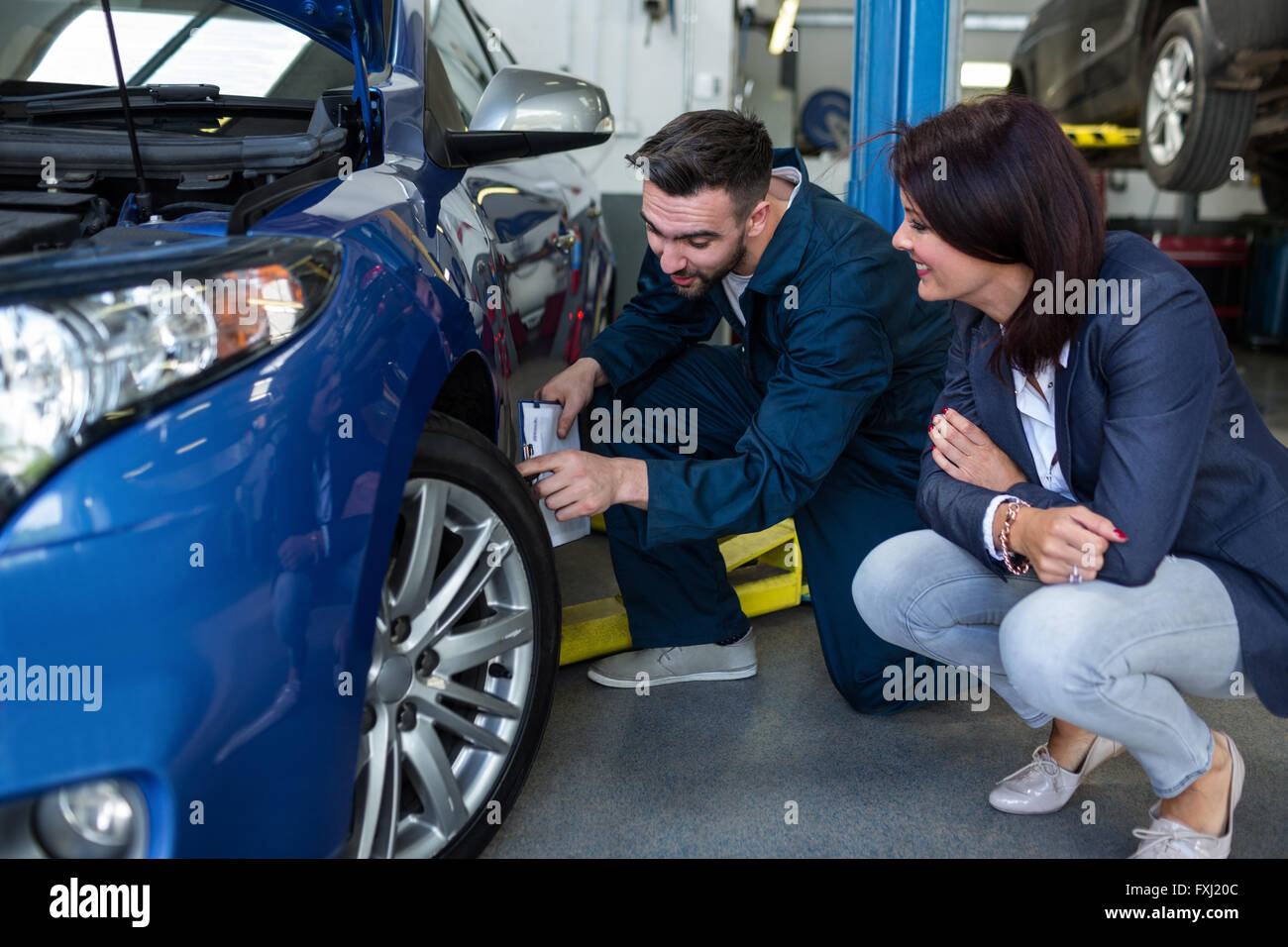 Mechanic showing customer the problem with car Stock Photo - Alamy