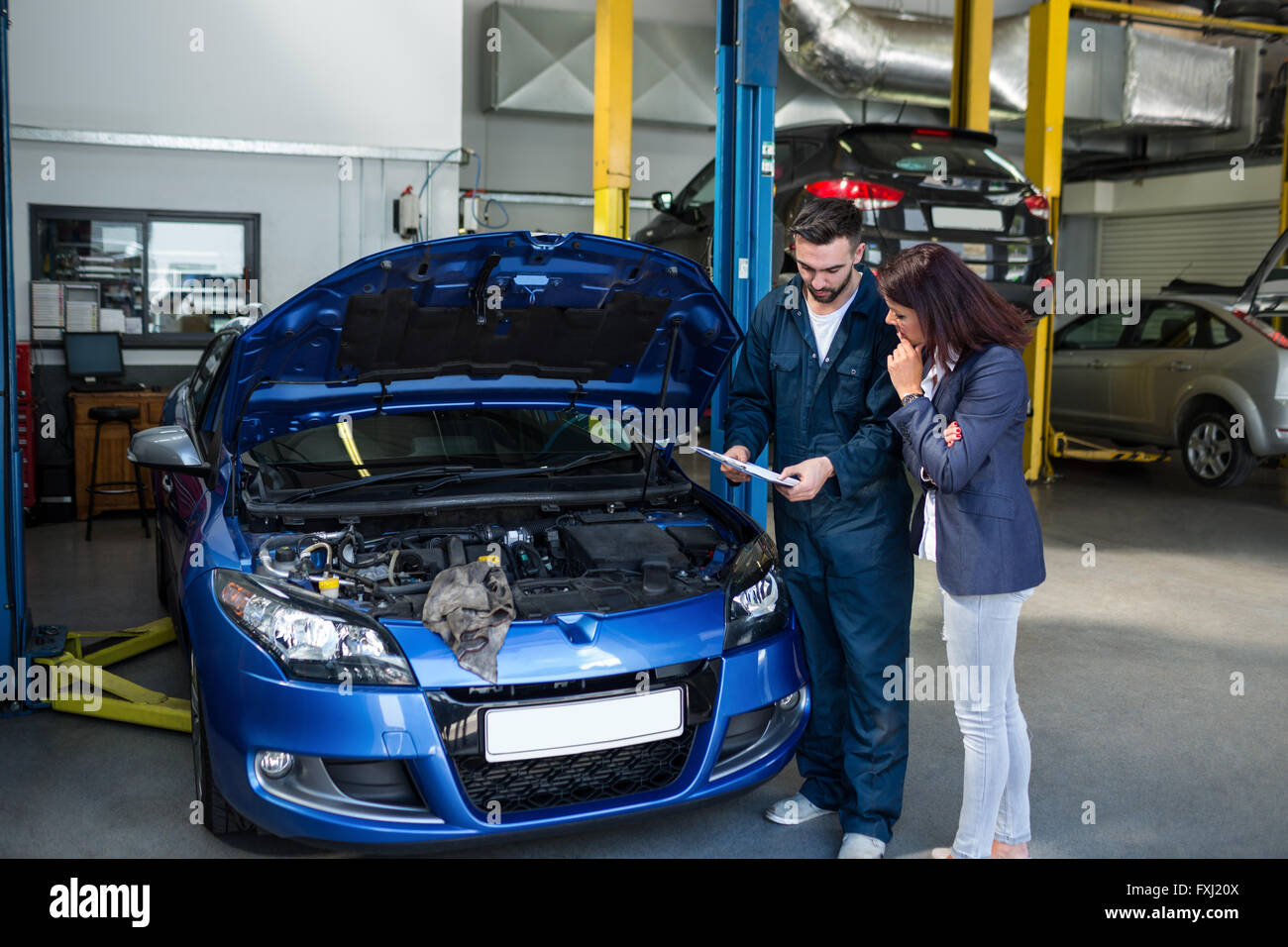 Mechanic showing the quotation to a customer Stock Photo - Alamy
