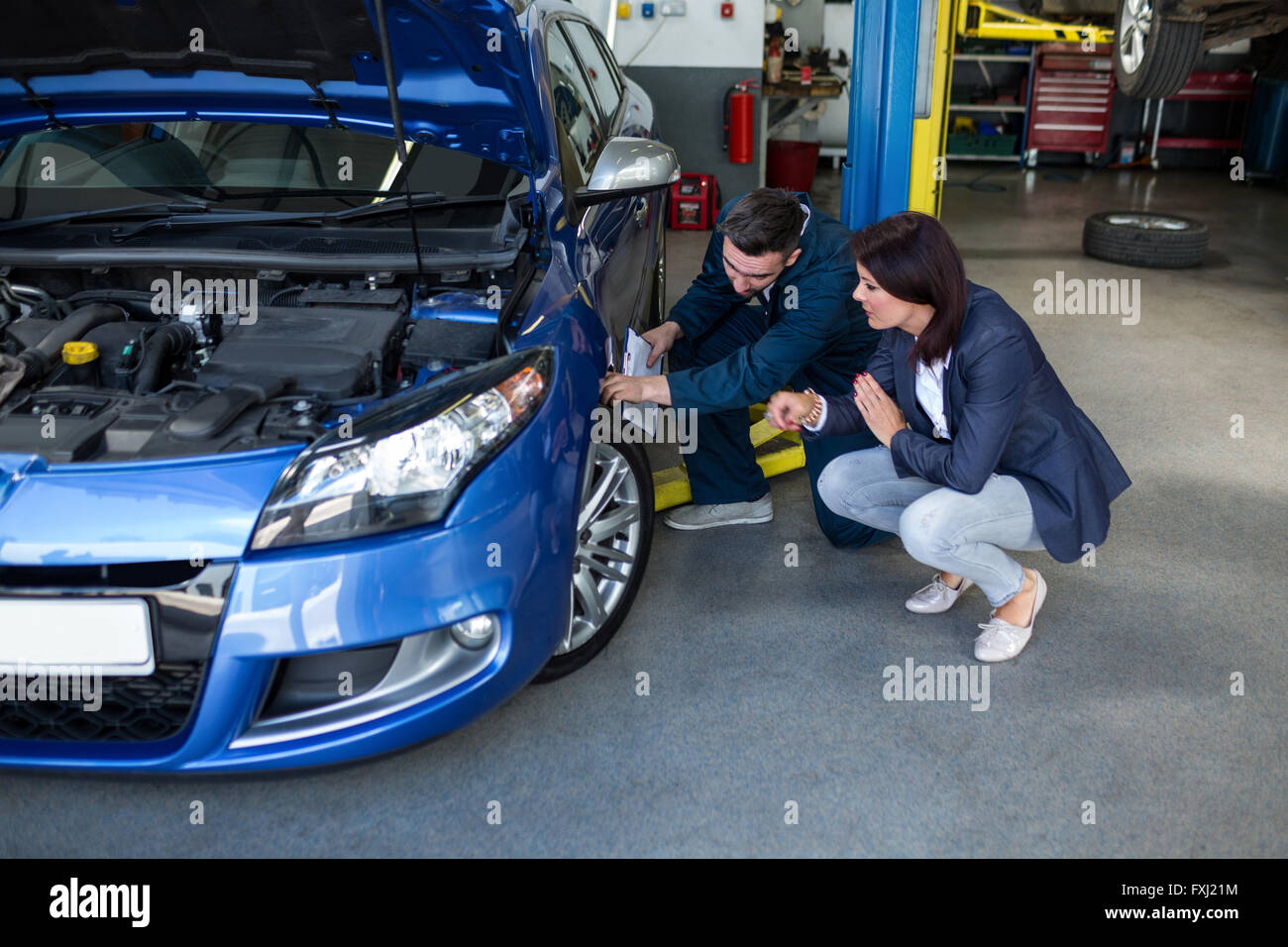 Mechanic showing customer the problem with car Stock Photo - Alamy