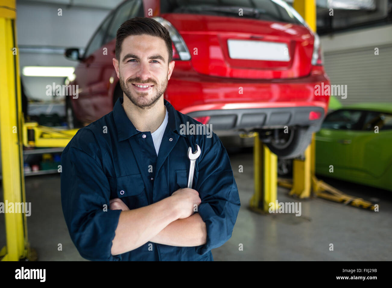Mechanic with arms crossed and spanner Stock Photo - Alamy