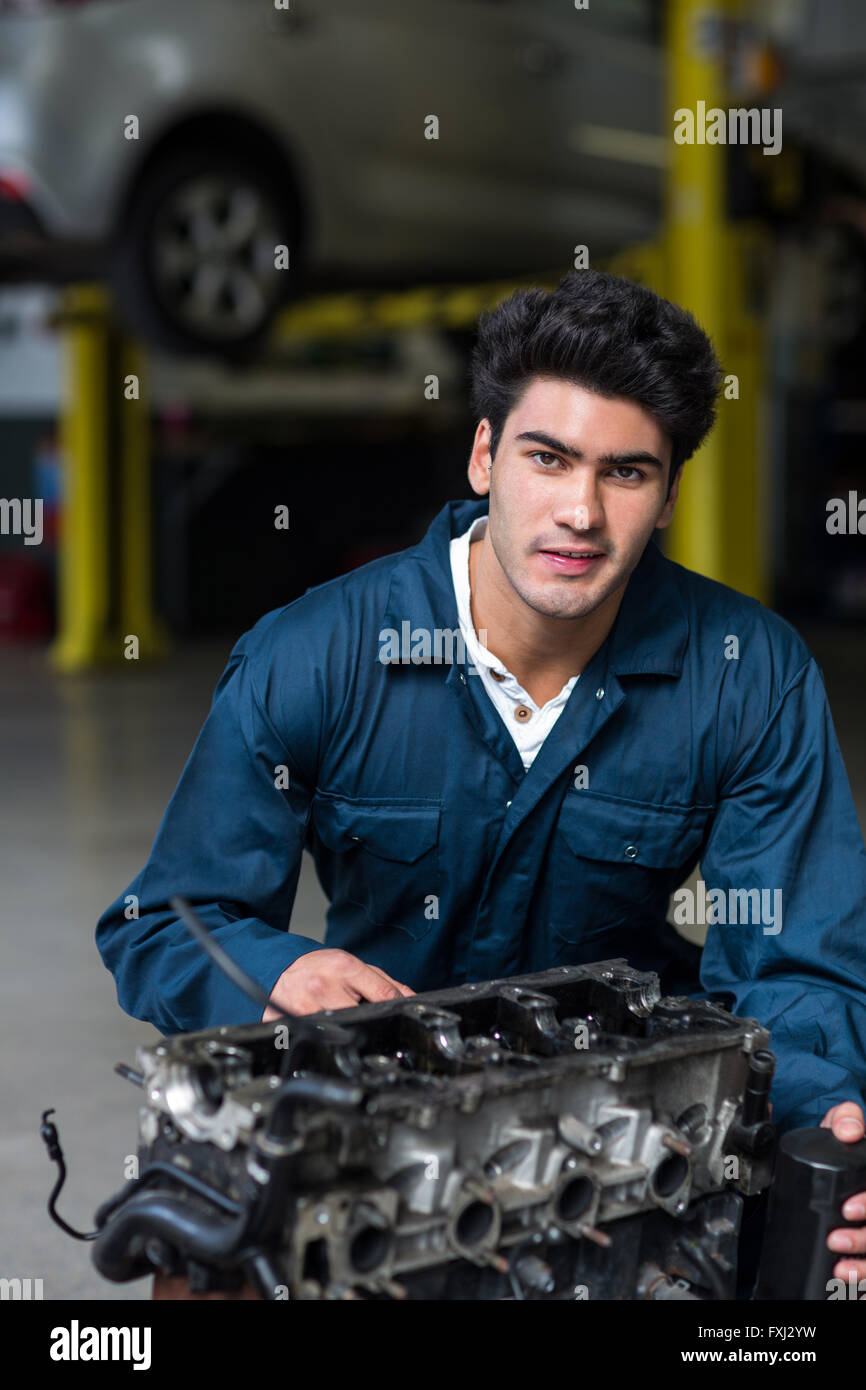Portrait of mechanic working on an engine at the repair garage Stock ...