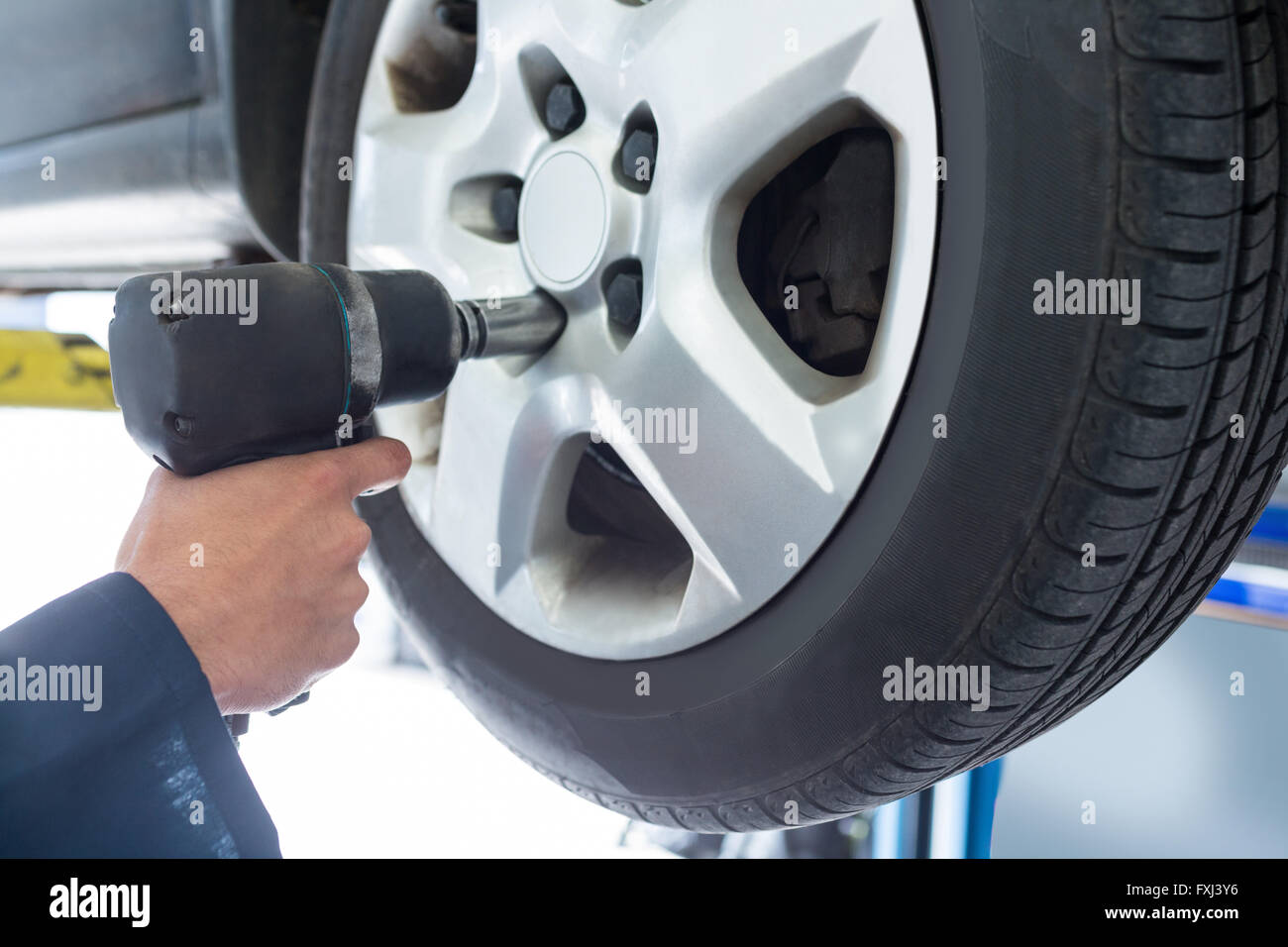 Mechanics hand fixing a car wheel Stock Photo - Alamy
