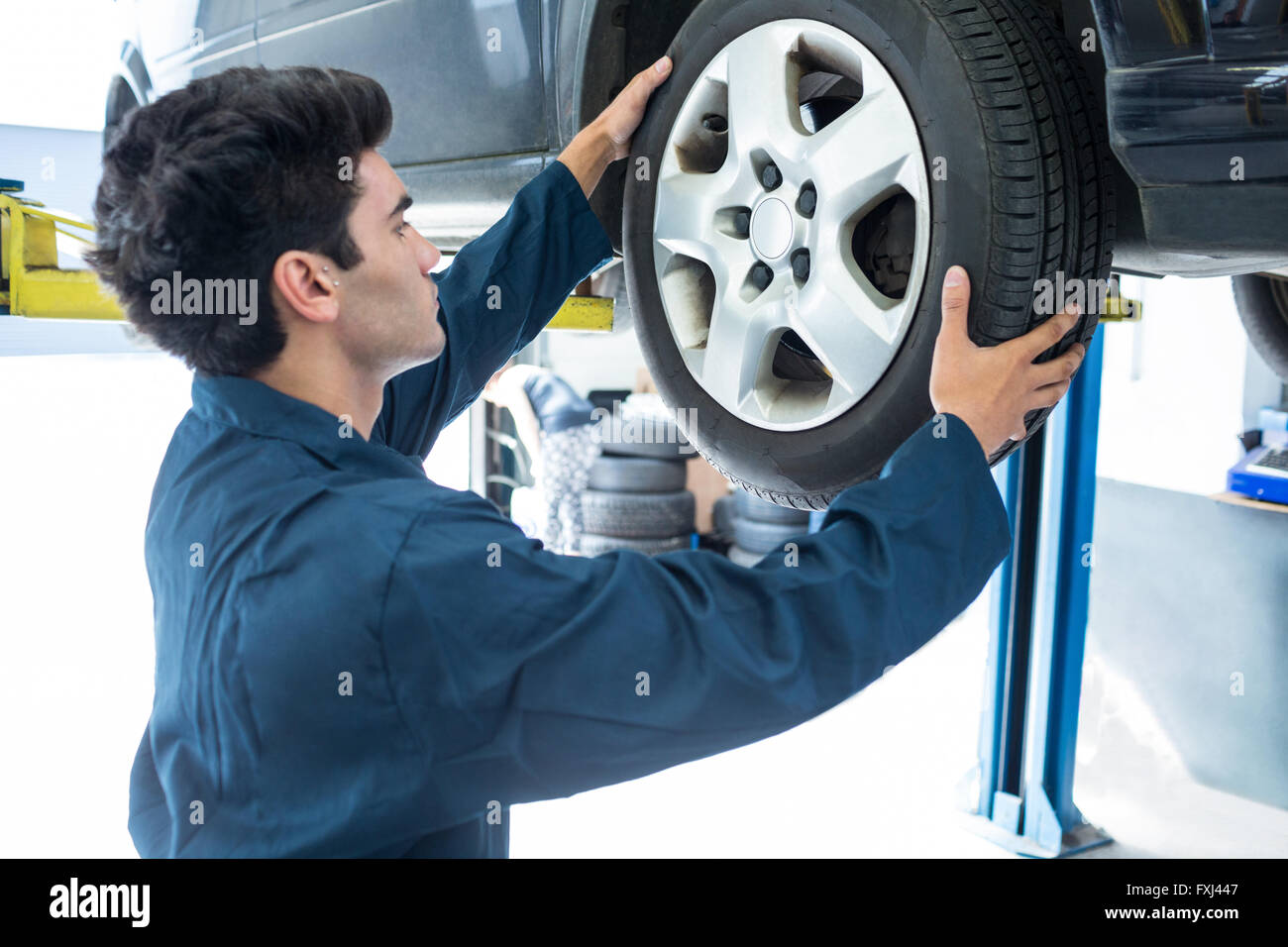 Mechanic fixing a car wheel Stock Photo - Alamy