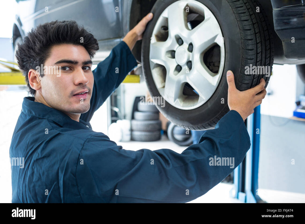 Mechanic fixing a car wheel Stock Photo - Alamy