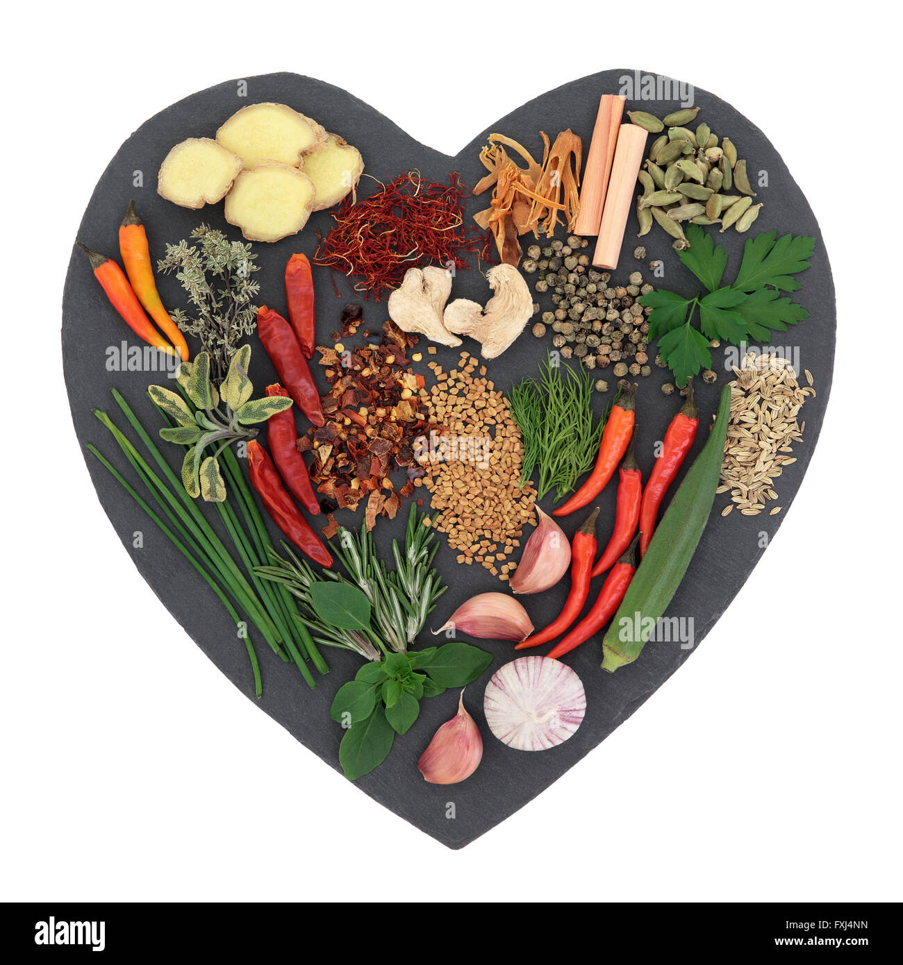 Herb and spice selection on heart shaped slate over white background ...