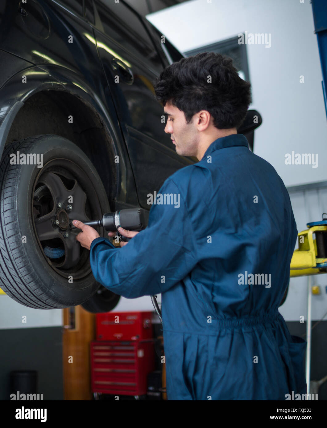 Mechanic fixing a car wheel Stock Photo - Alamy