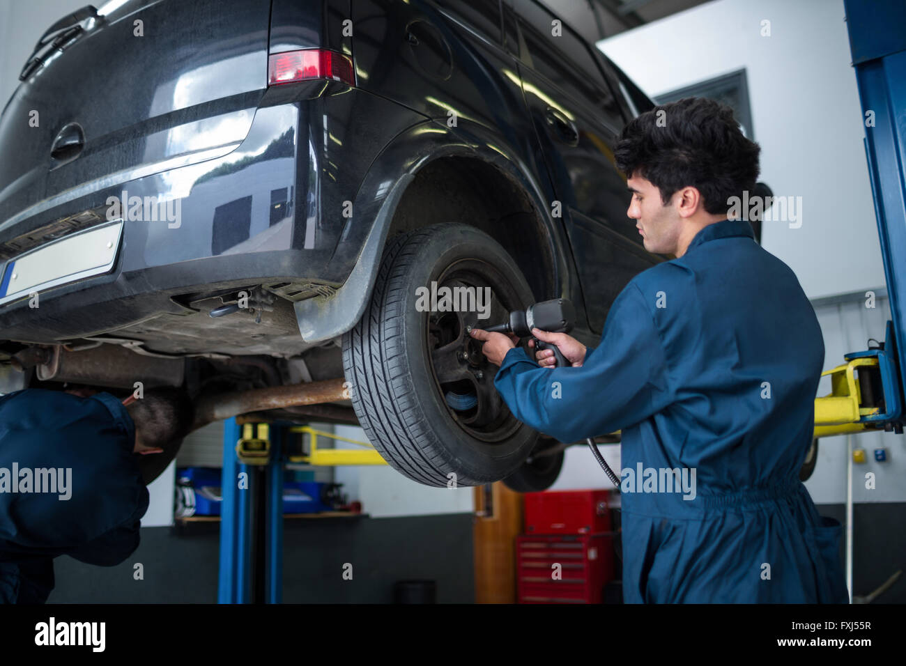 Mechanic fixing a car wheel Stock Photo - Alamy