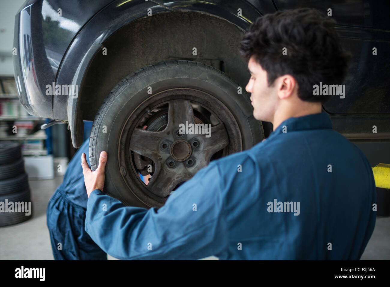 Mechanic fixing a car wheel Stock Photo - Alamy
