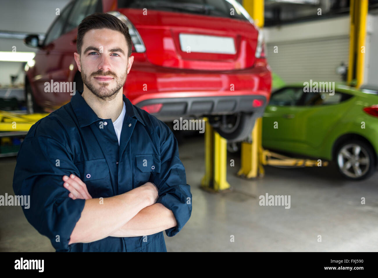 Mechanic with arms crossed smiling at camera Stock Photo - Alamy