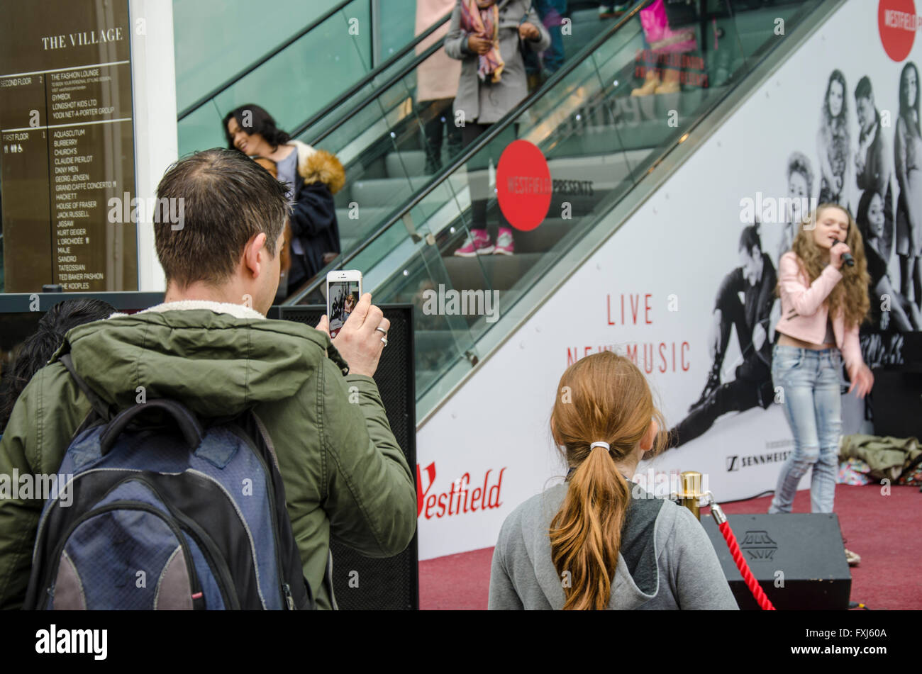 A man photographs a teenage singer known as 'Sapphire' as she performs ...