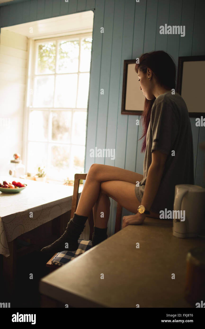 Young woman sitting on the table Stock Photo - Alamy