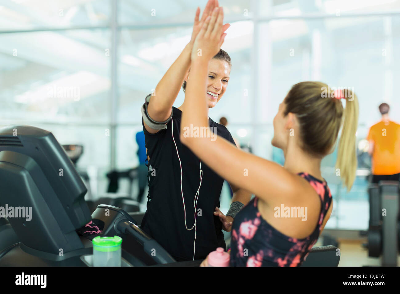 Smiling women high fiving at gym Stock Photo - Alamy