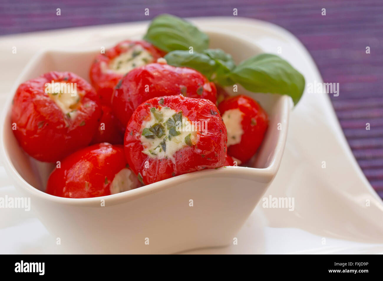 Spicy round red peppers stuffed with cheese, garnished with basil. The ...