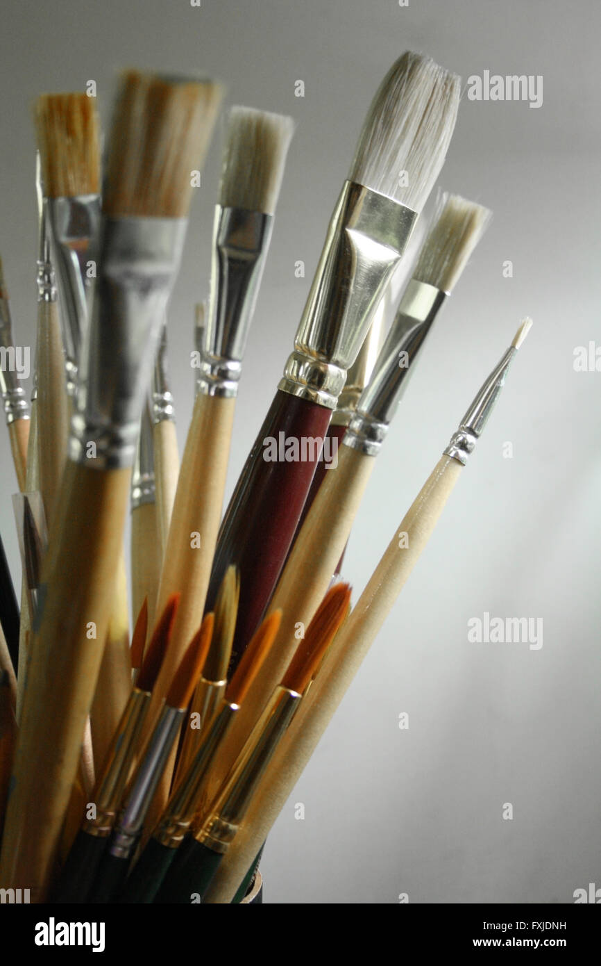 Bunch of painting brushes kept in a holder forming conical shapes ...