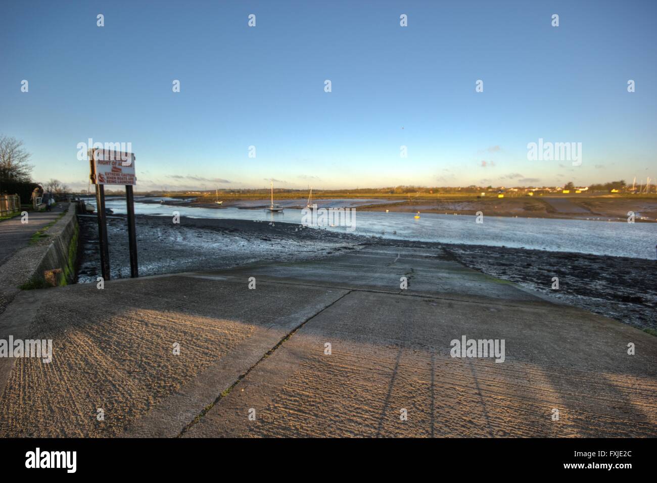Sun rising above river slipway Stock Photo - Alamy