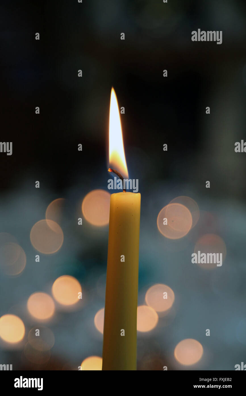 It's a photo of a candle with the little flame, It is in focus with an ...
