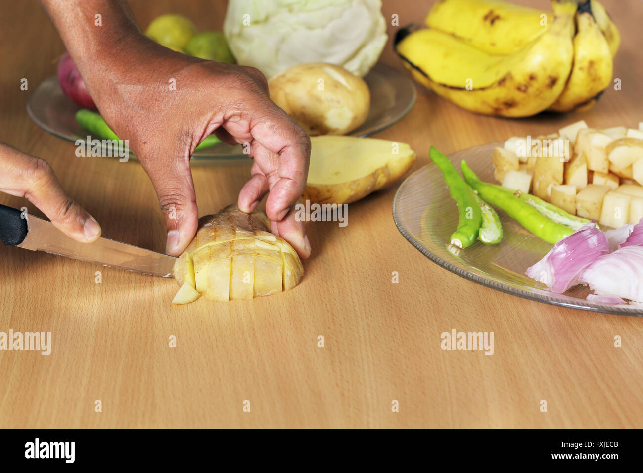 Slicing and preparing vegetable ingredients for making Indian curry ...