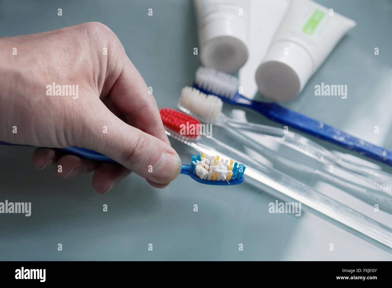 Hand And Toothbrushes Stock Photo - Alamy