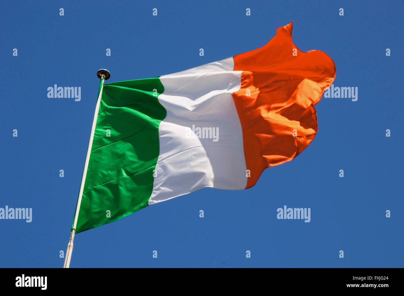Irish flag fluttering in a brisk breeze against a bright blue sky Stock ...
