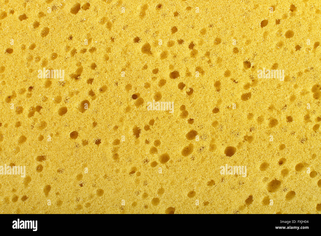 Yellow washing sponge with holes and bubbles used for cleaning ...