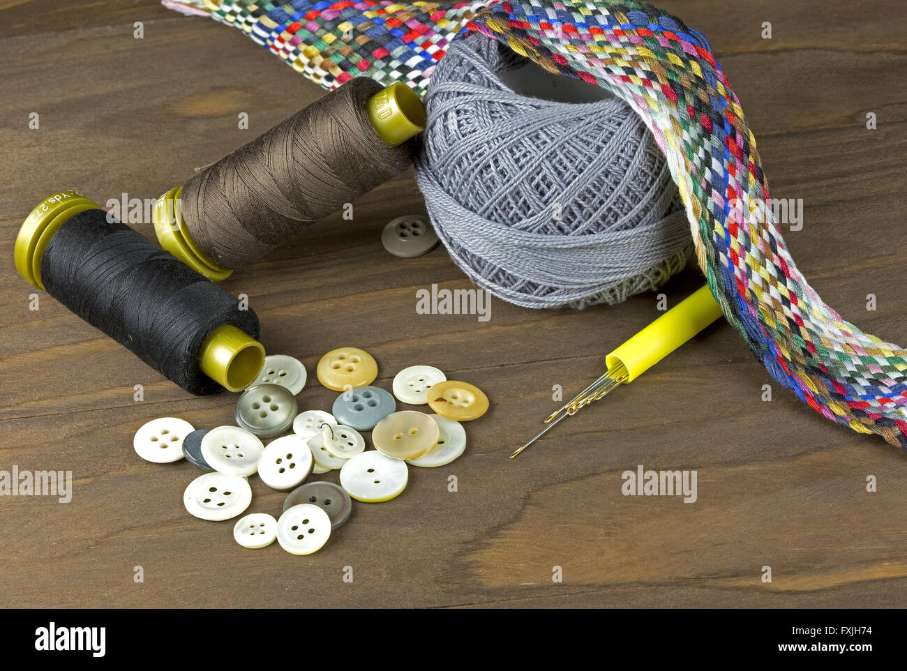 A collection of sewing tools and supplies isolated on a wooden ...