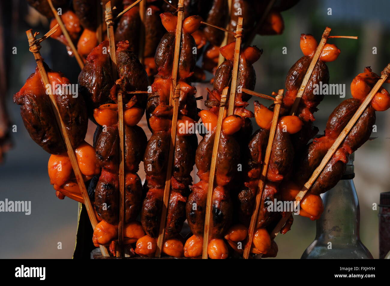 sunlit BBQ frogs on a stick, skewers, for sale along National Highway 2 ...