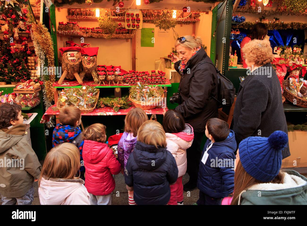 A woman explains to a group of small children about the Tio de Nadal or ...