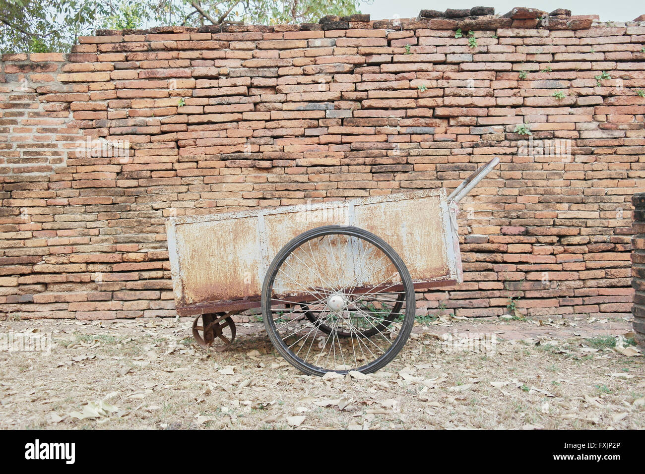 Old Wheelbarrow stand in front of a wall Stock Photo - Alamy