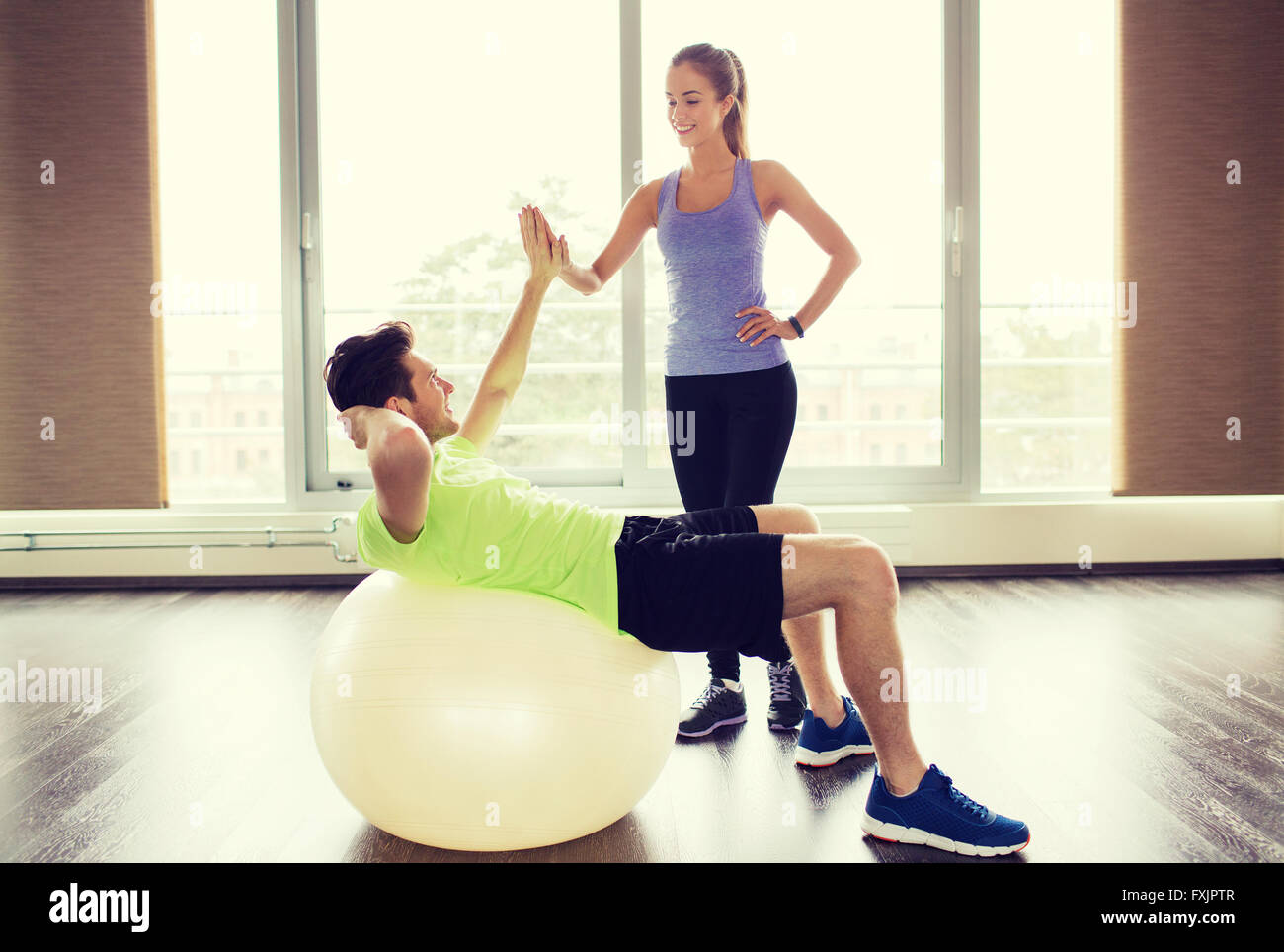 smiling man and woman with exercise ball in gym Stock Photo - Alamy