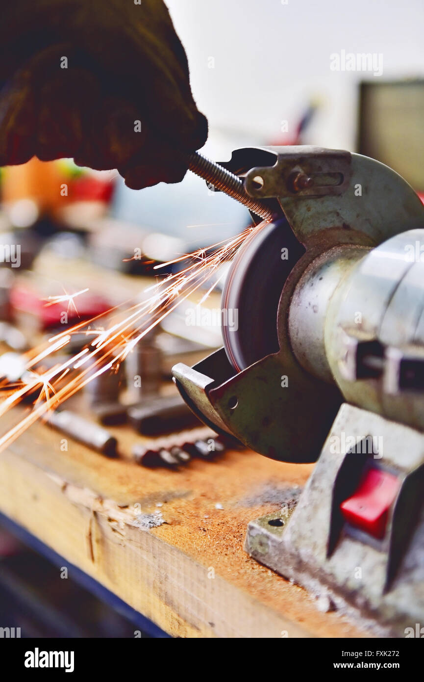 Vintage photo with mechanic polishing a screw on industrial polishing ...