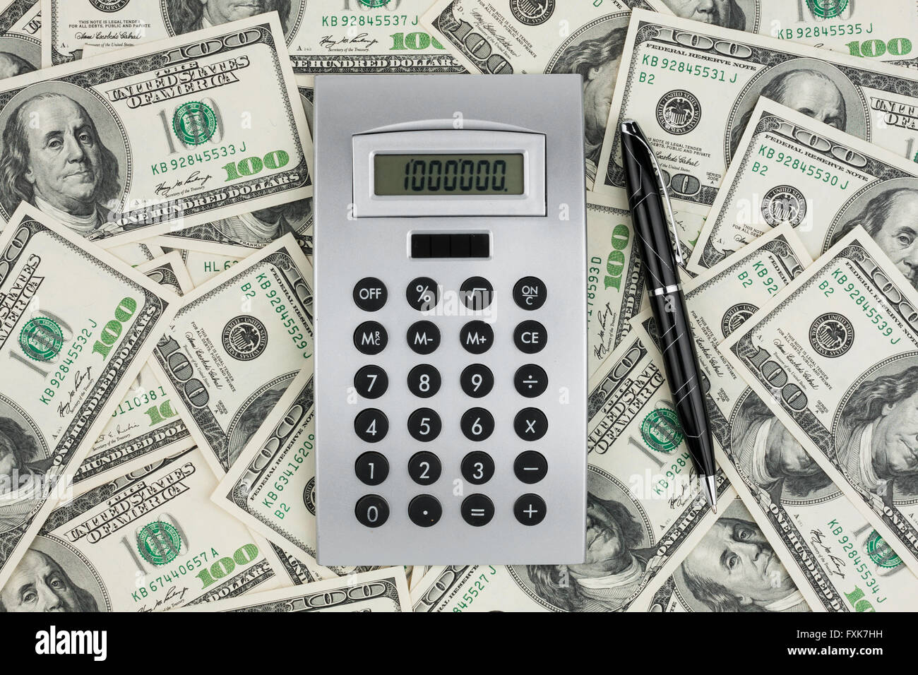 Calculator and pen lying on the million dollar. as background Stock ...