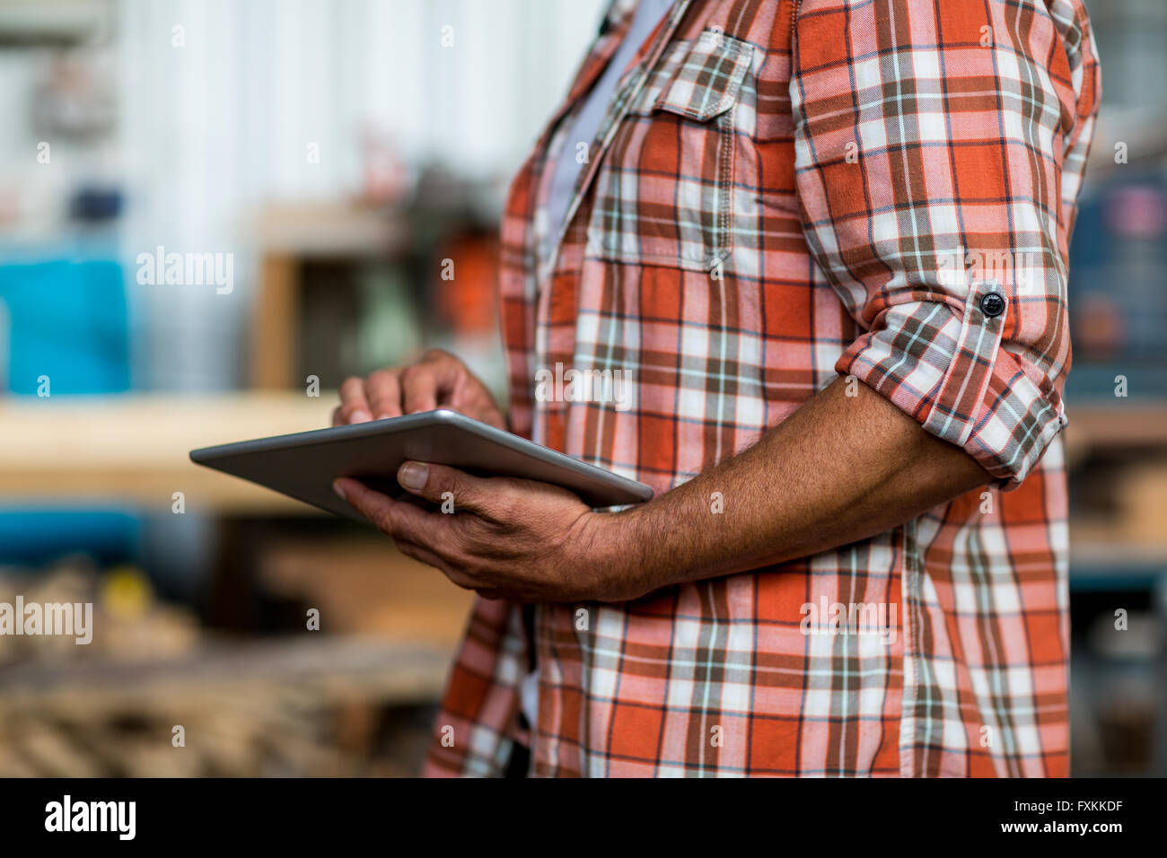 Mid section of carpenter using digital tablet Stock Photo - Alamy