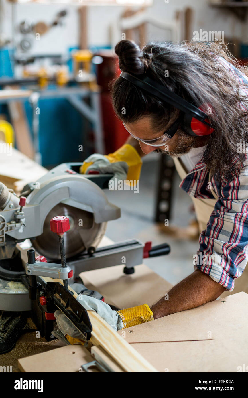 Carpenter cutting wooden plank with electric saw Stock Photo - Alamy