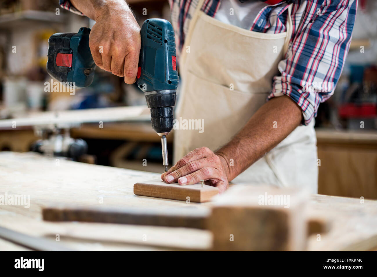 Carpenter drilling a hole in a wooden plank Stock Photo - Alamy