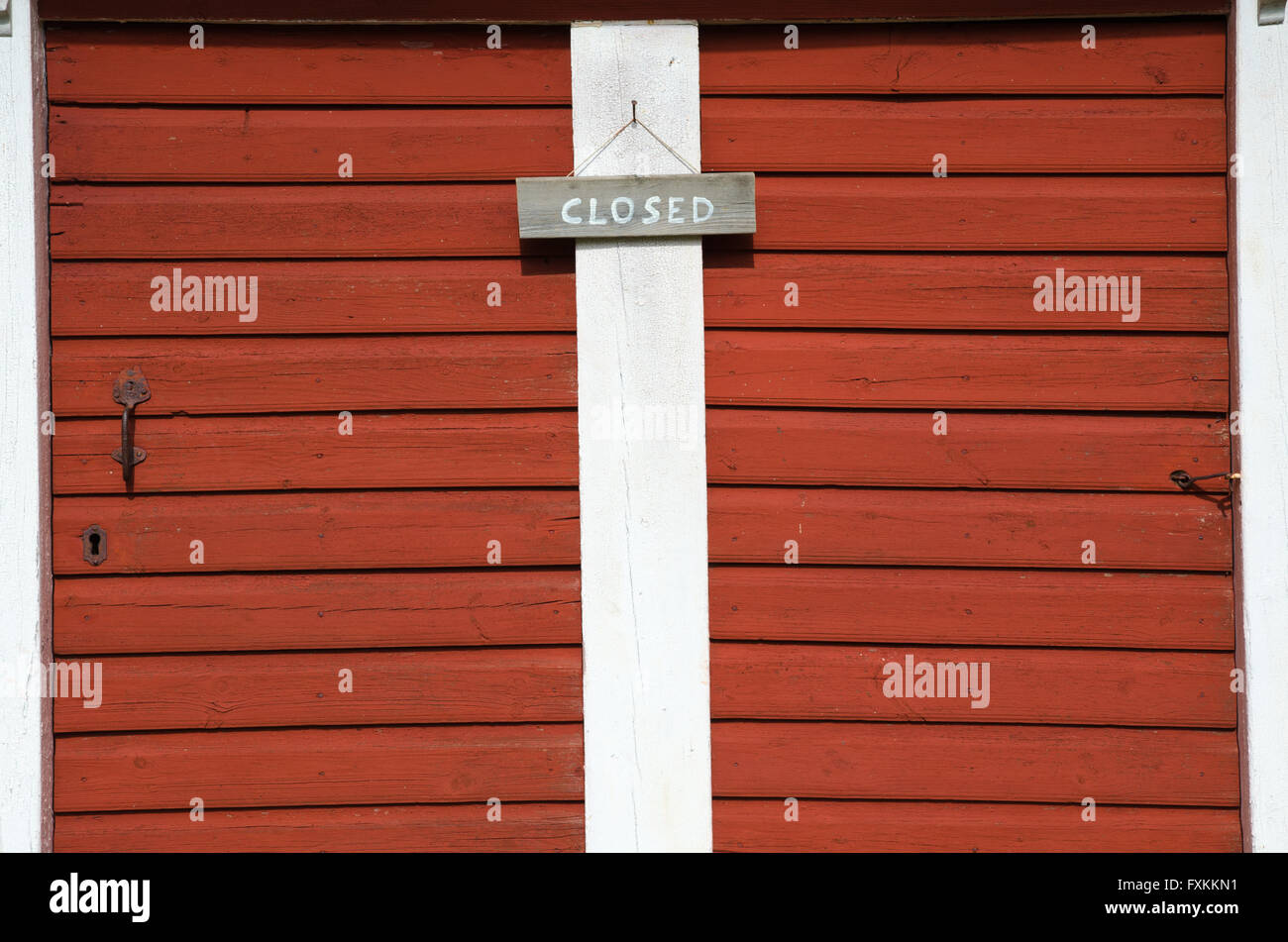 Written closed sign hanging on two red old wooden doors Stock Photo - Alamy