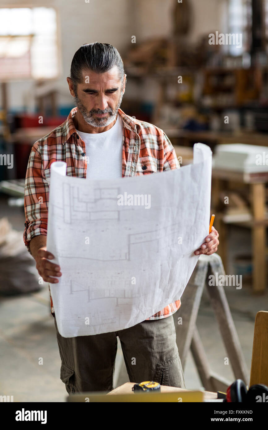 Carpenter looking at a blueprint Stock Photo - Alamy