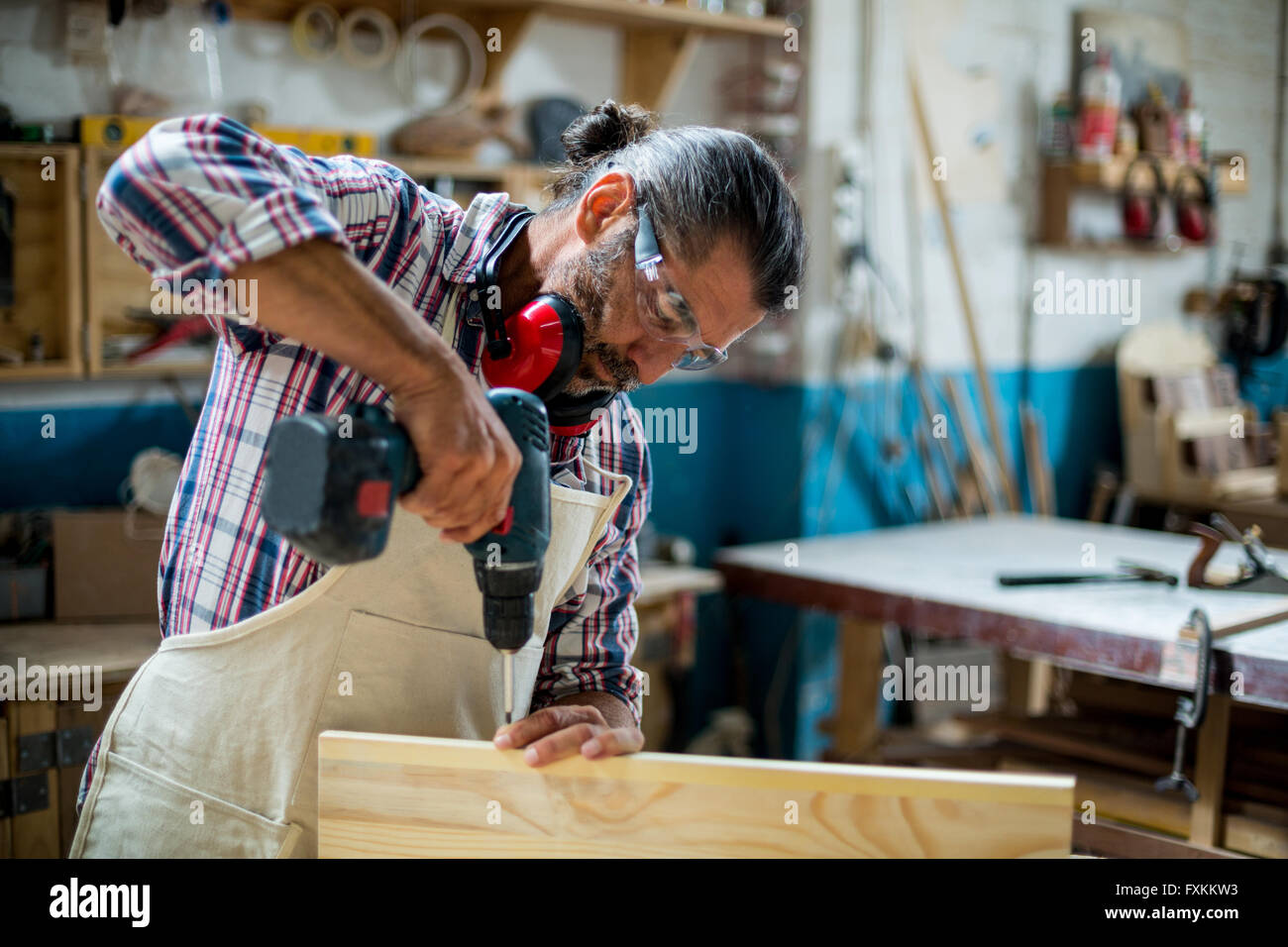 Carpenter drilling a hole in a wooden plank Stock Photo - Alamy