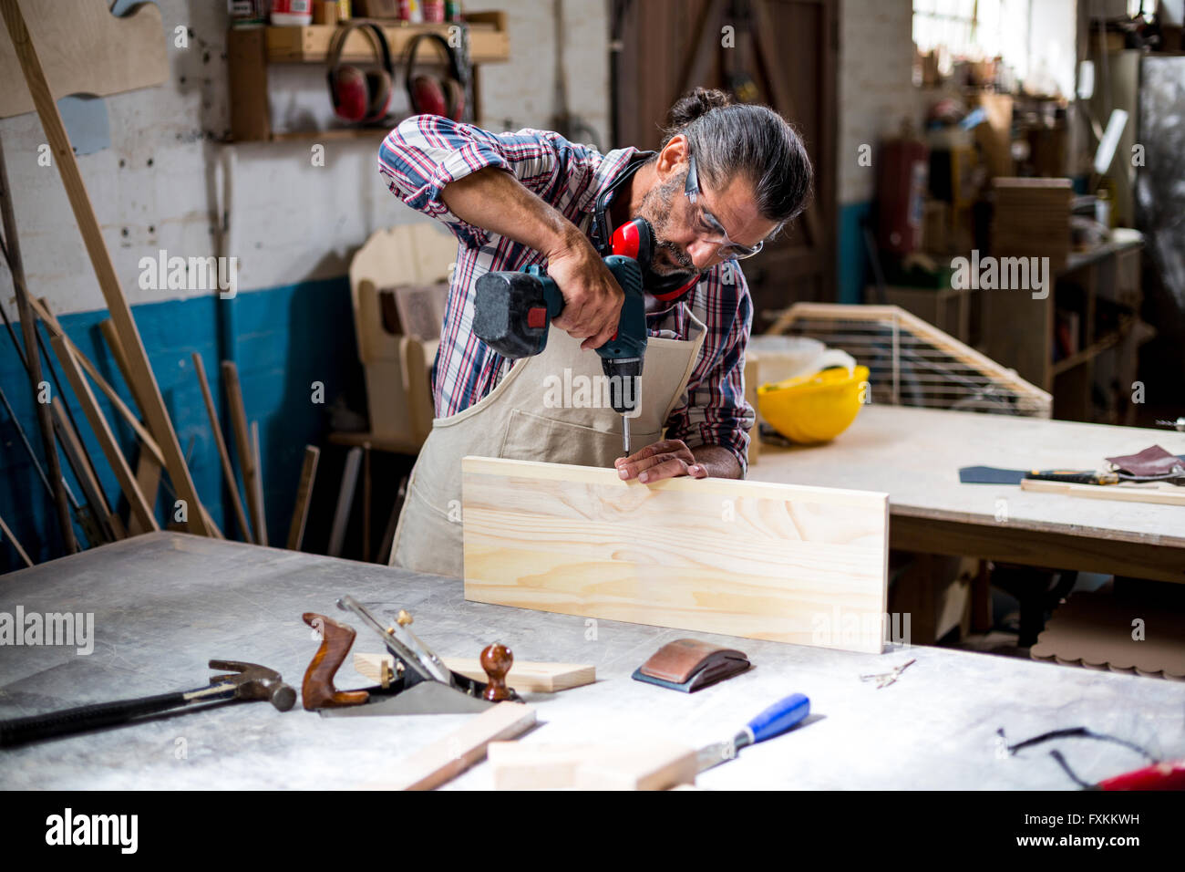 Carpenter drilling a hole in a wooden plank Stock Photo - Alamy
