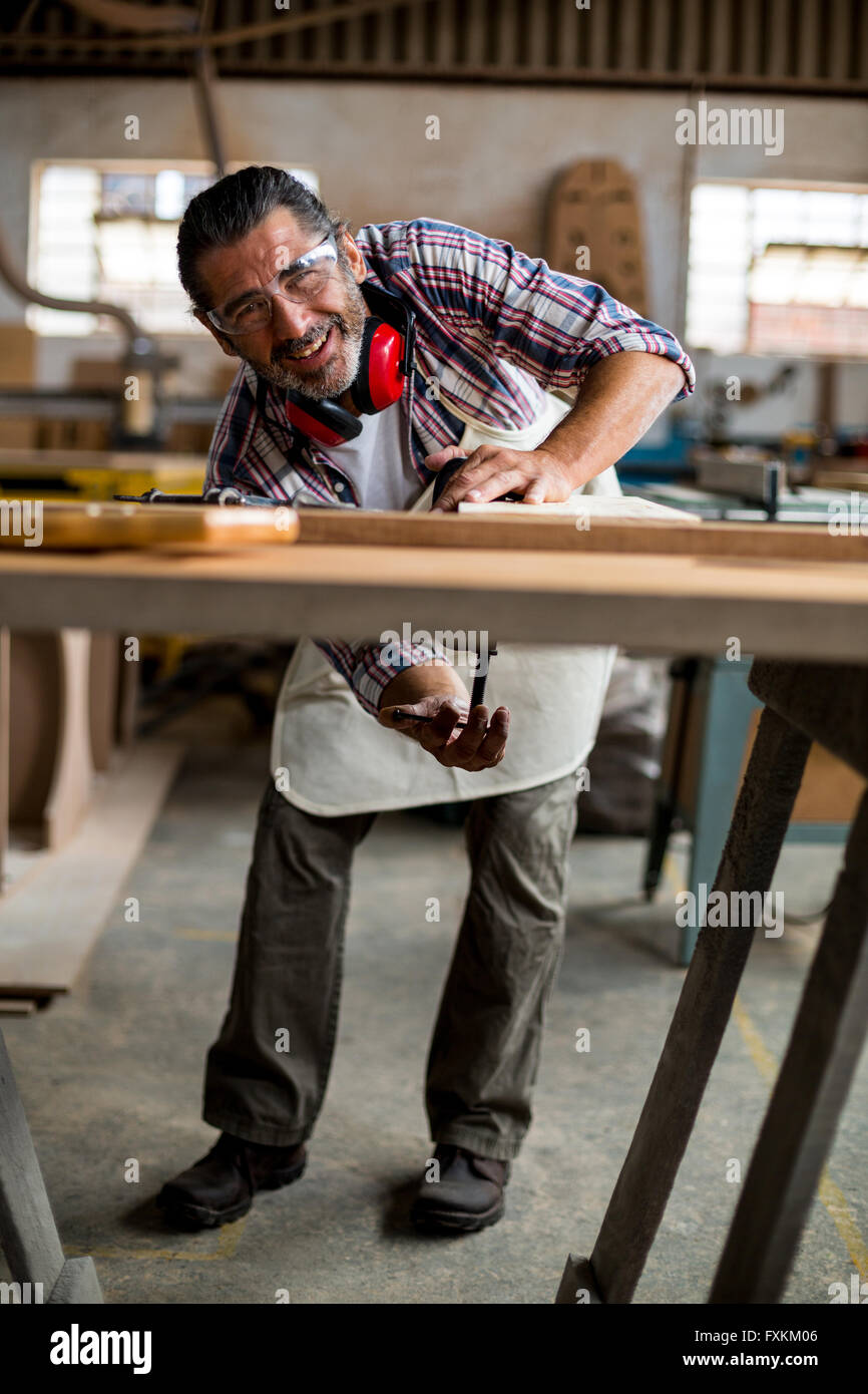 Carpenter working on wooden plank in workbench Stock Photo - Alamy