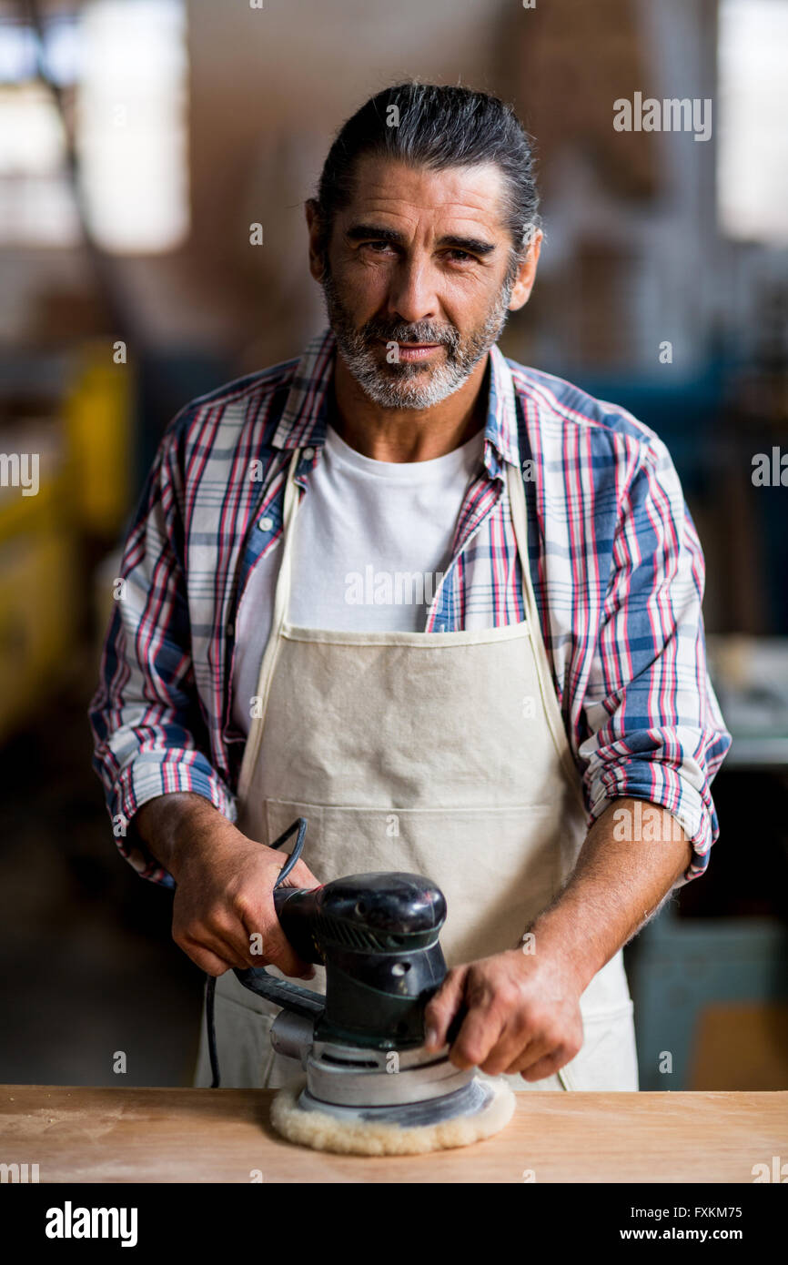 Carpenter polishing a wooden plank with polishing machine Stock Photo ...