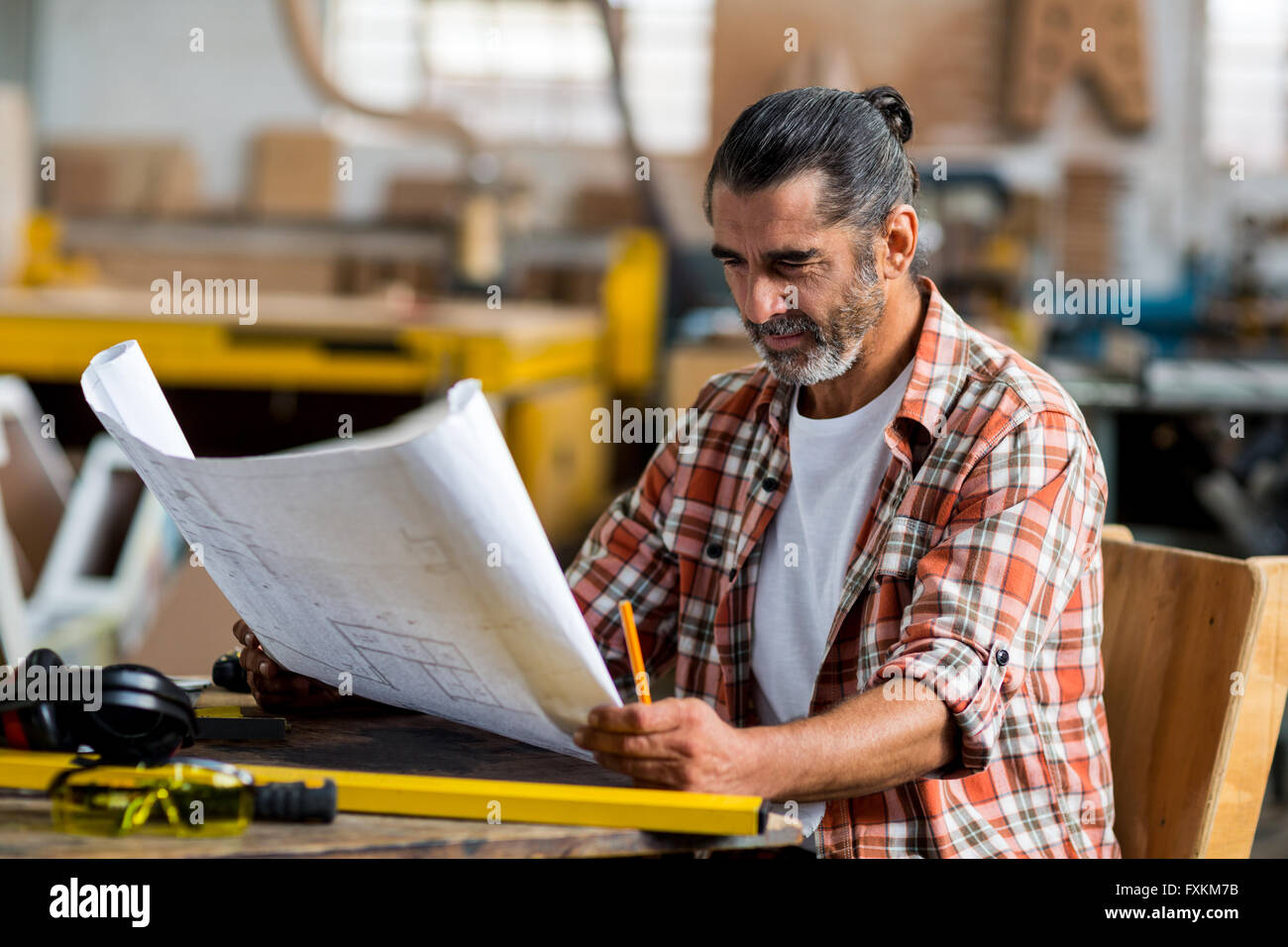 Carpenter looking at a blueprint Stock Photo - Alamy