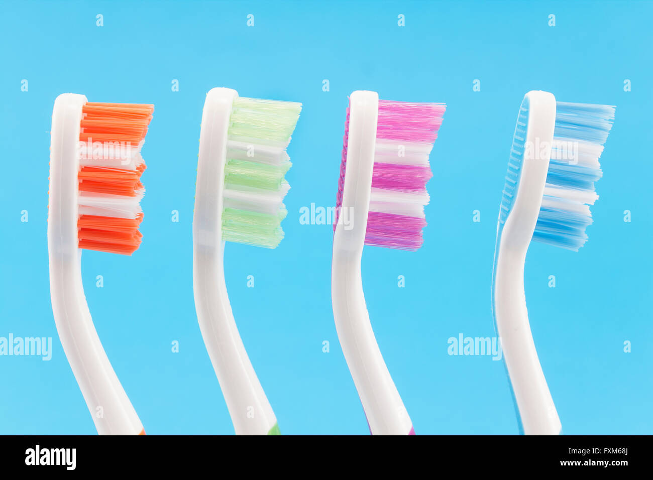 Colourful toothbrushes isolated on blue Stock Photo - Alamy