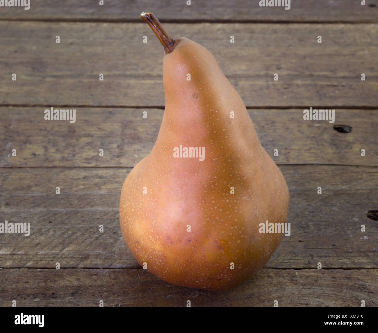 Close up of single Bosc pear on rustic wood table Stock Photo - Alamy